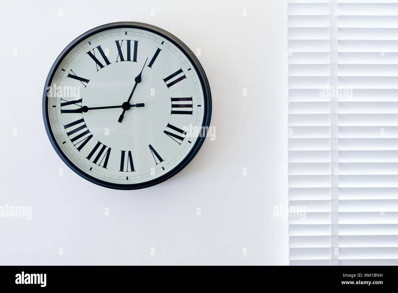 A black and white wall clock on the white background Stock Photo - Alamy