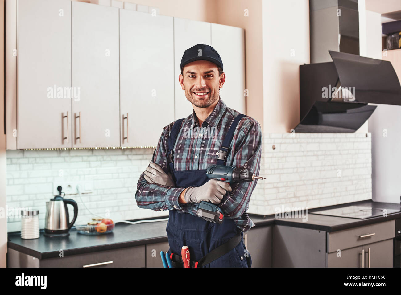 Modern handyman. Portrait of a smiling male foreman standing with ...