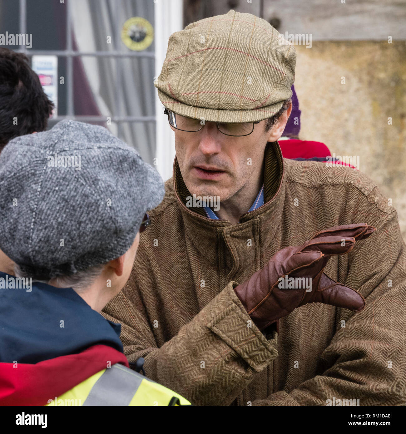 A man in vintage clothing, cap and gloves in conversation Stock Photo ...