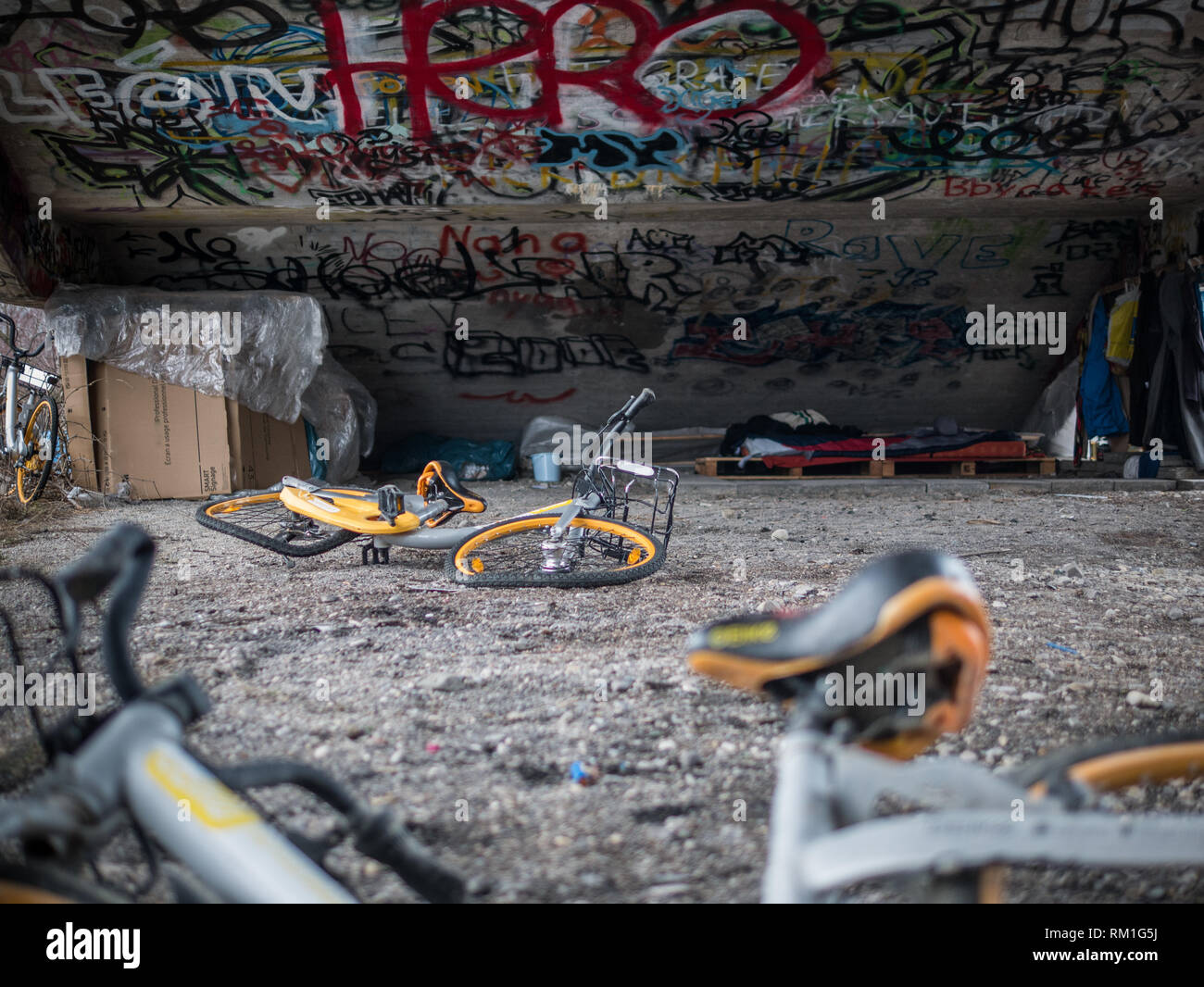 Old yellow scrap bicycles under concrete stairs with graffiti and ...