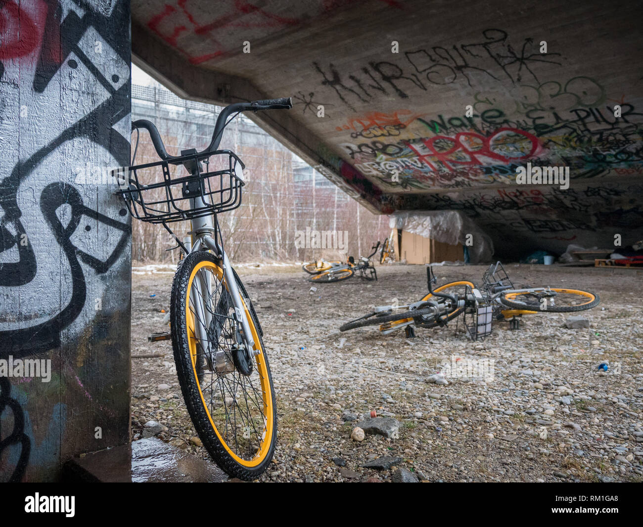 Old yellow scrap bicycles under concrete stairs with graffiti and ...