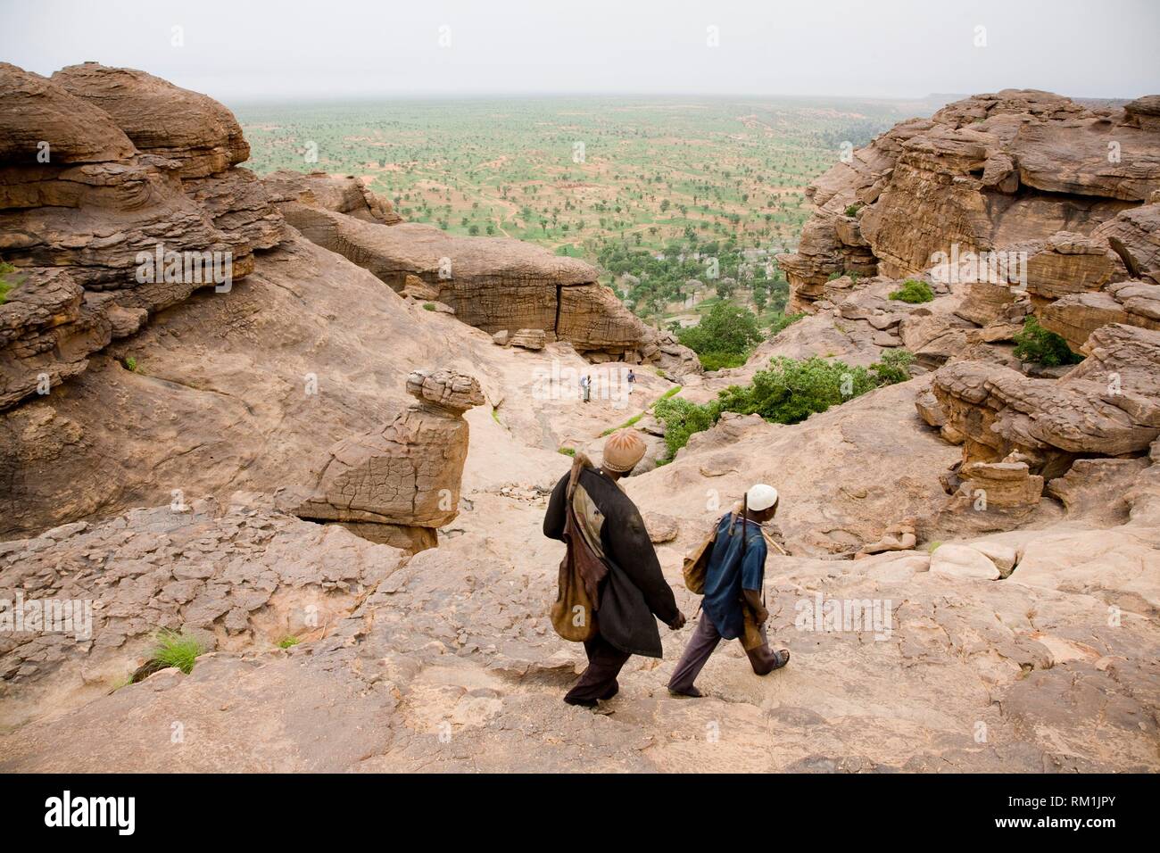 Mali. Dogon Country. Two men (hunters and peasants) descending on a ...