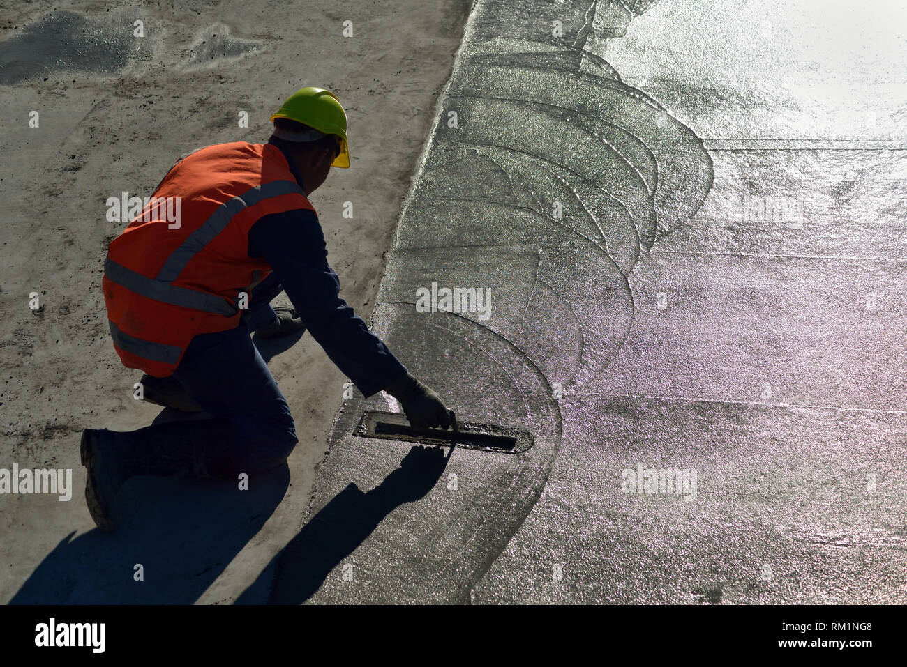 A builder floating off new concrete for a large building Stock Photo ...