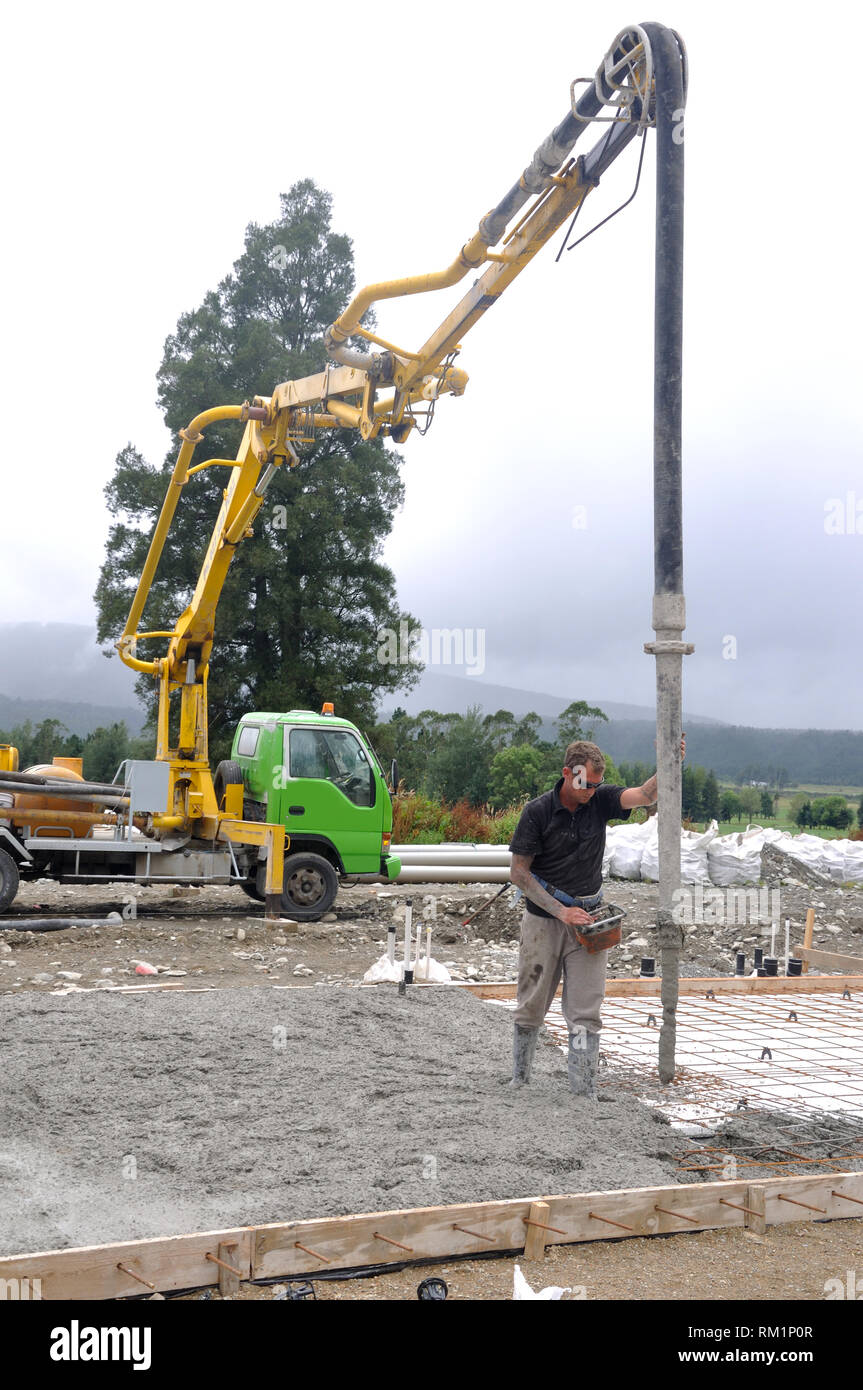 Builder uses a concrete pump to direct wet concrete into the ...