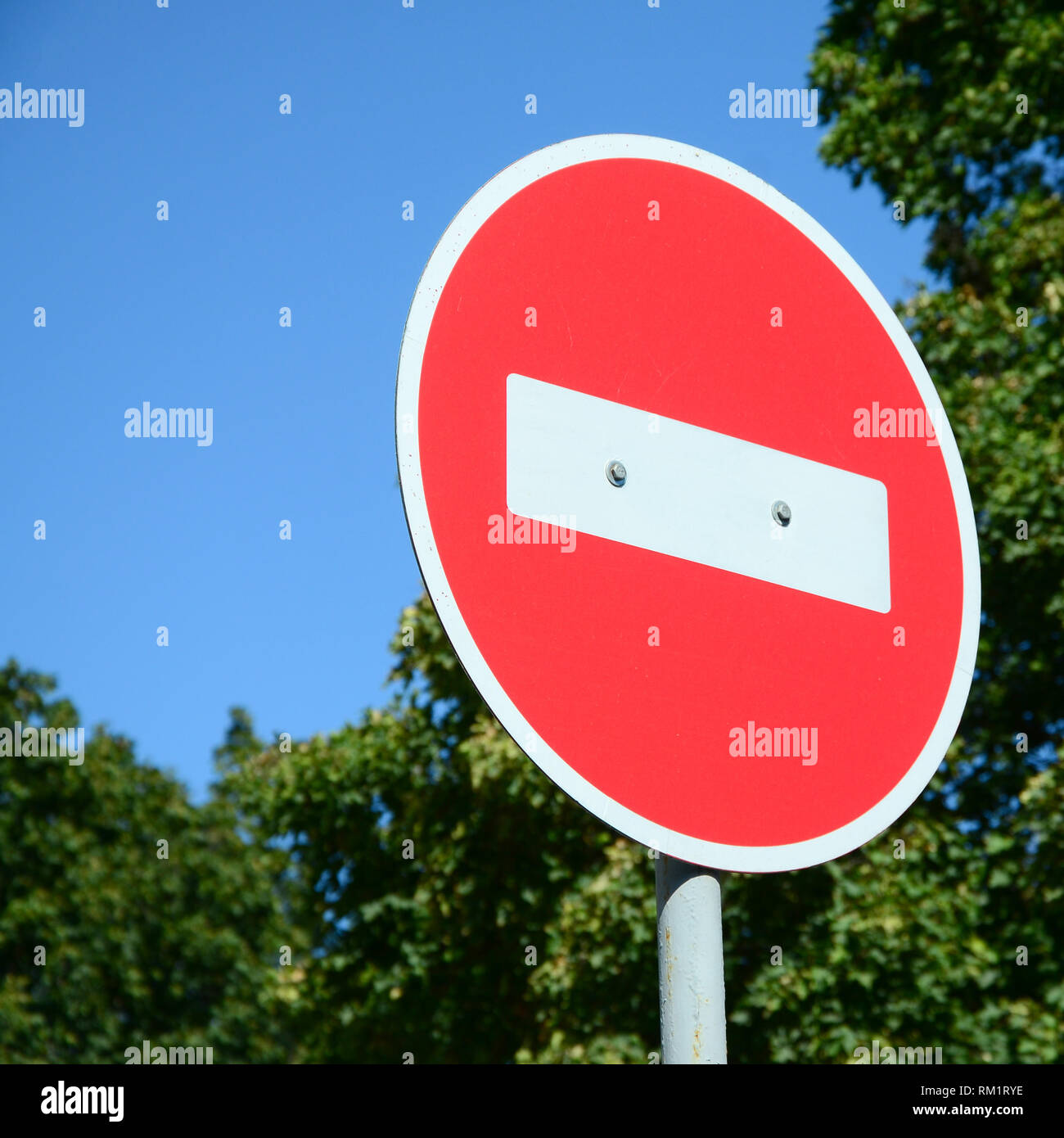 A circular red sign with a white bar indicating NO ENTRY on a grey ...