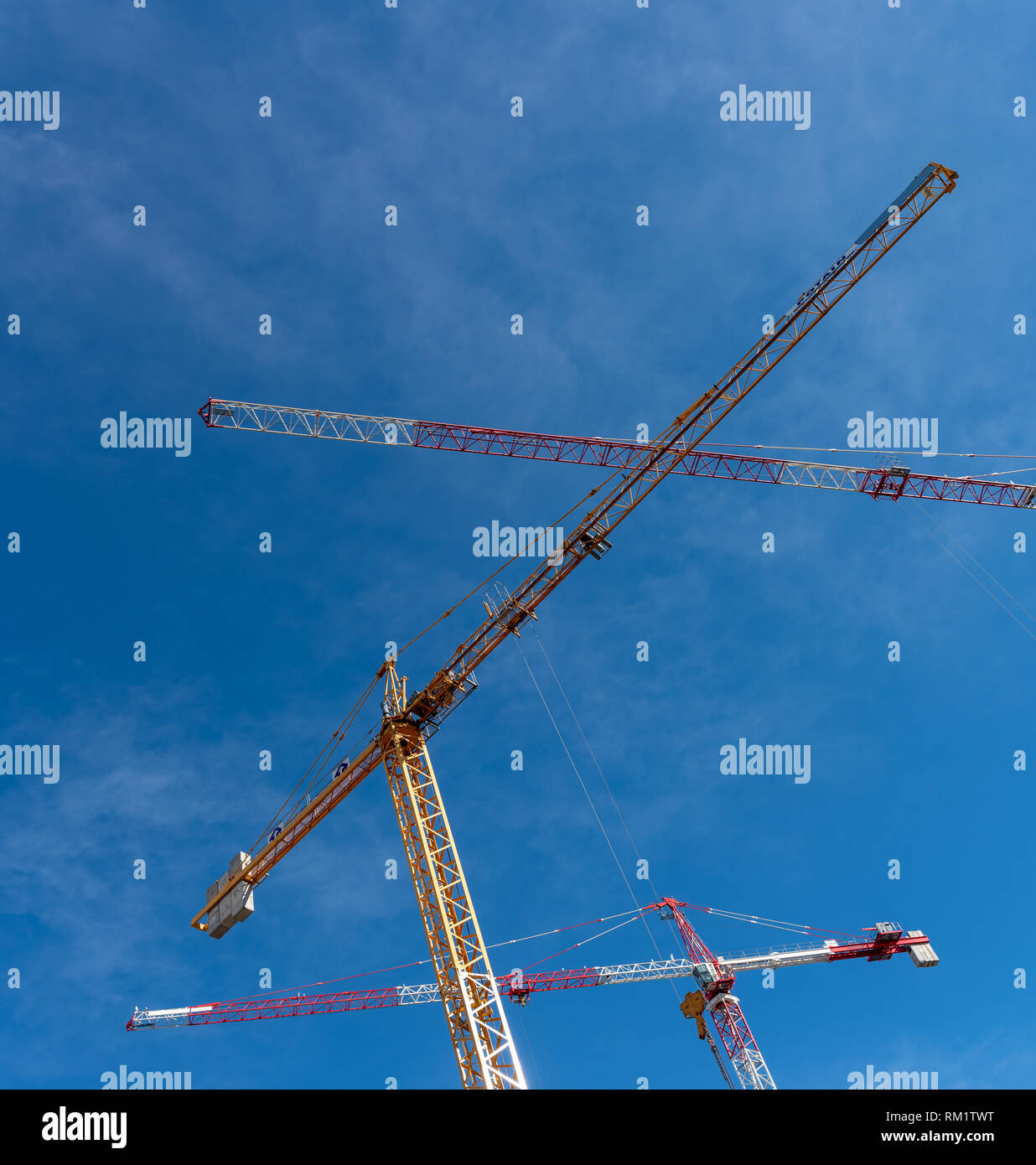 tall cranes from a construction site rising into the sky, contruction ...