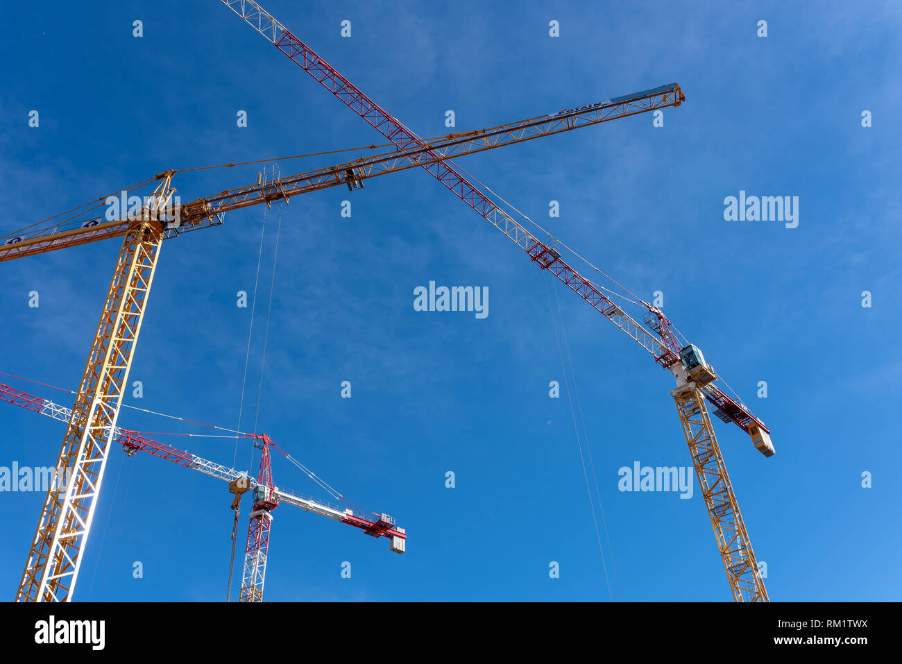 tall cranes from a construction site rising into the sky, contruction ...