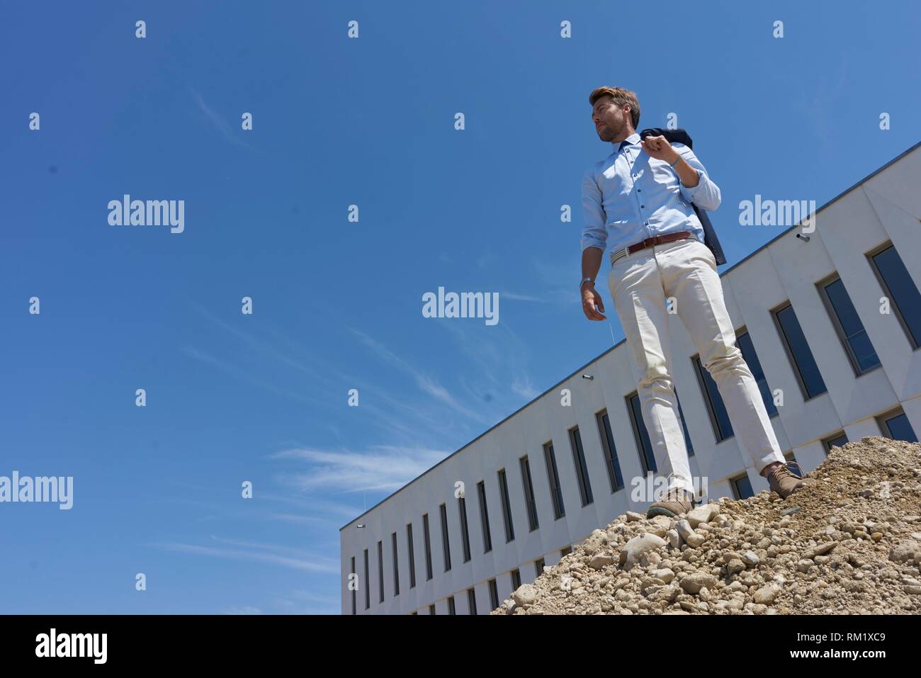 Business man standing on building site in front of architecture ...