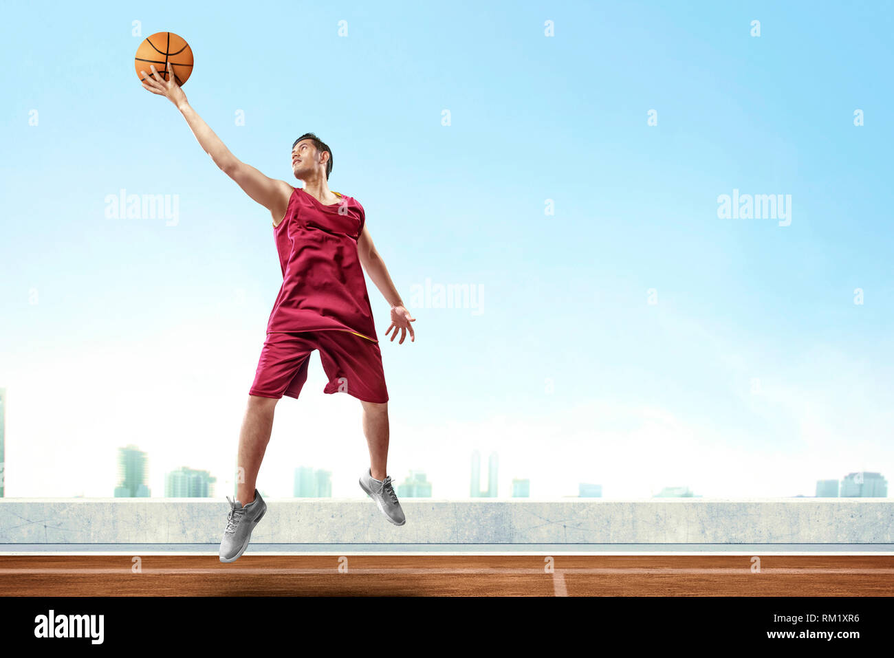 Handsome asian man basketball player jumping high and rebound the ball ...