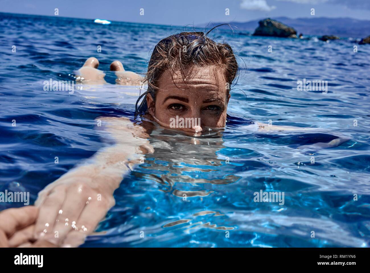 Greece, Crete, Chersonissos, woman in lagoon, trapping hand Stock Photo ...