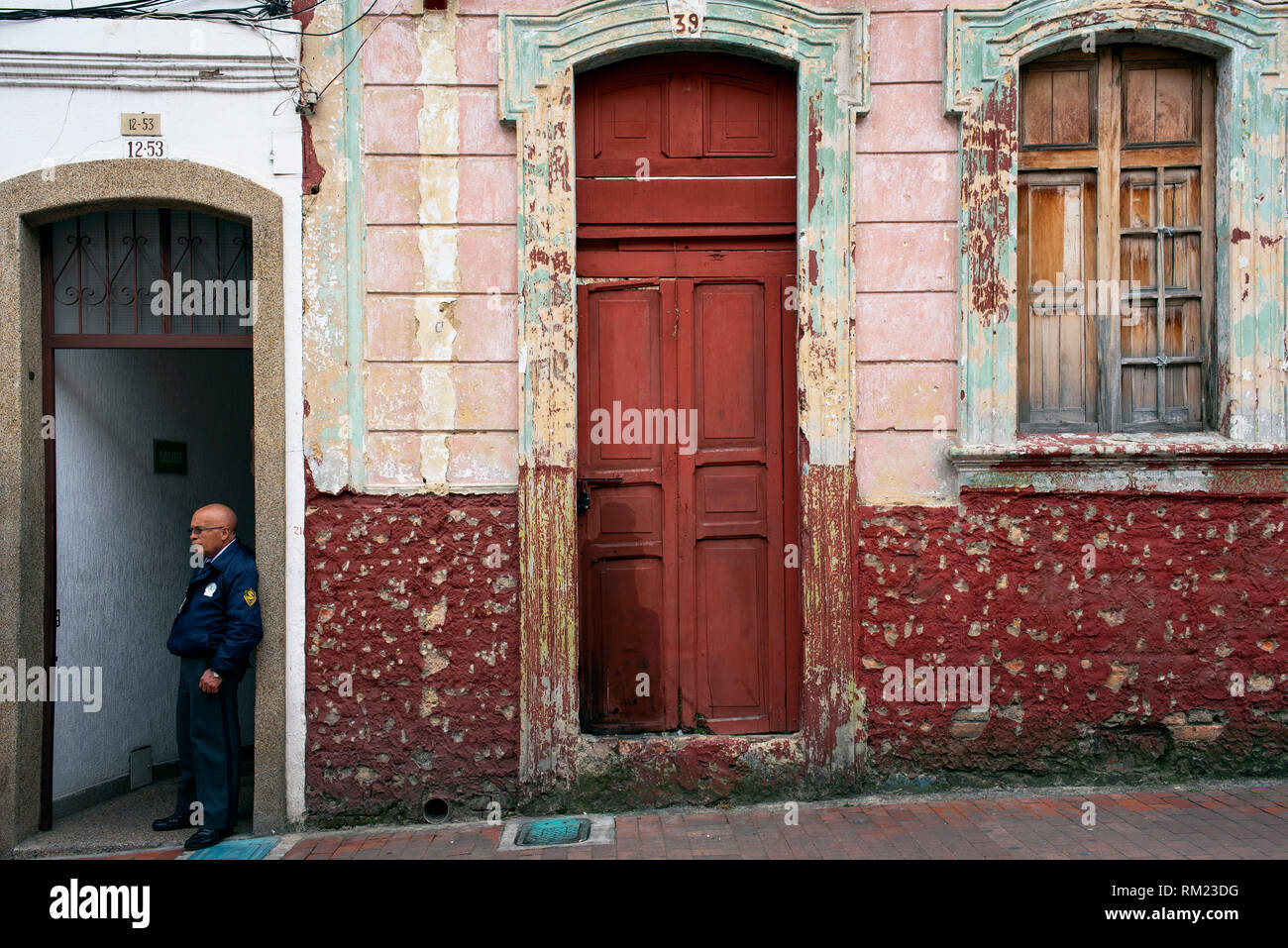 Security man in uniform standing at the entrance of a colonial building ...