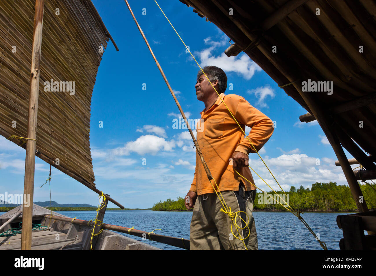 A MOKEN MAN sails his traditional boat to KHO RA ISLAND in the Andaman ...