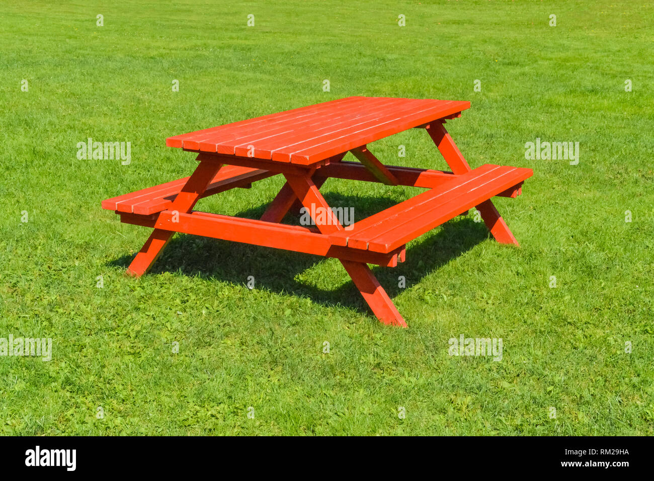 Red picnic table on green lawn in a park Stock Photo - Alamy