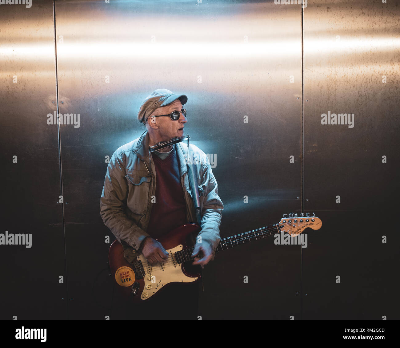 Male busker playing guitar in blue neon lit underpass fort william ...
