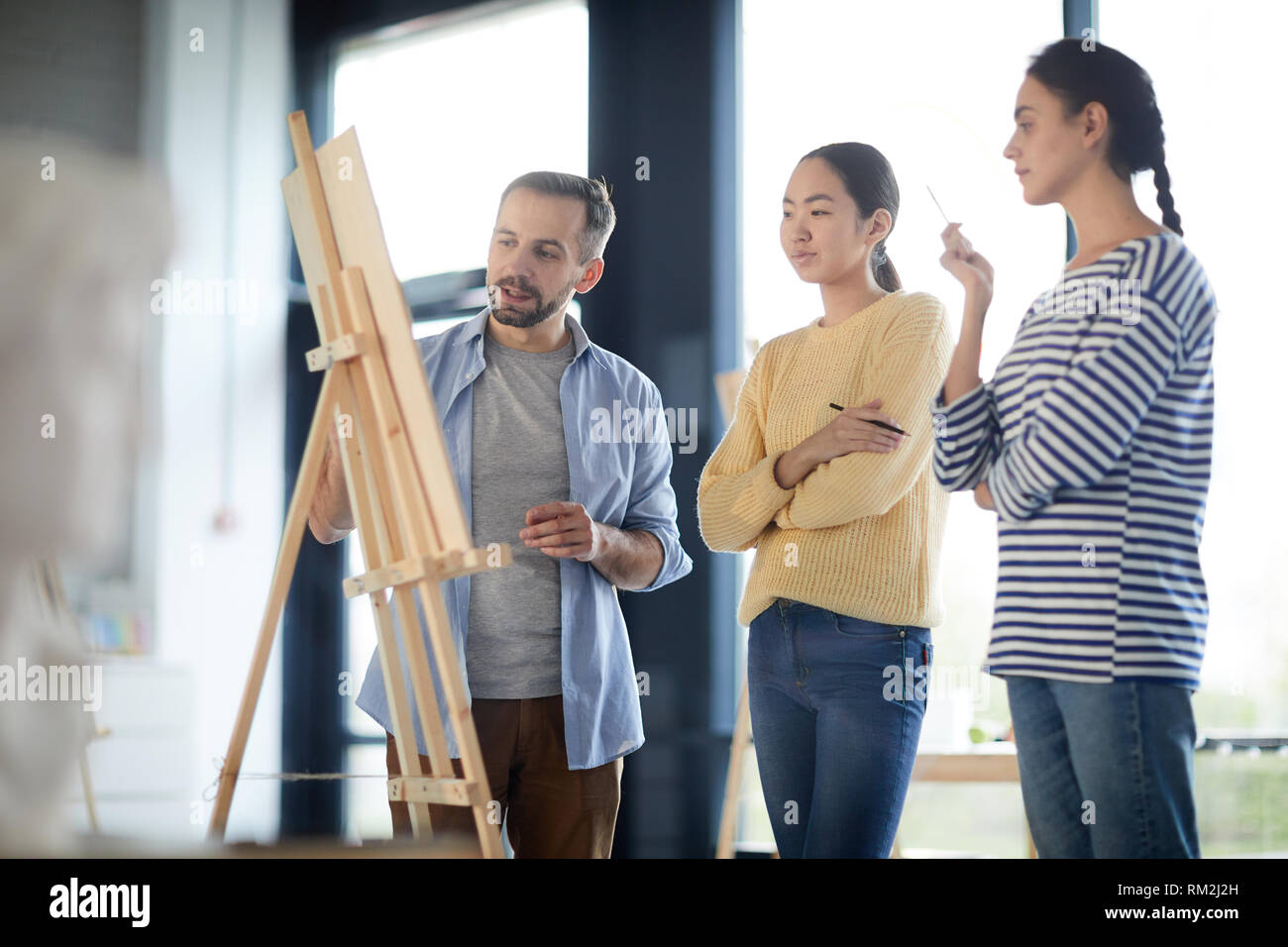 Students and teacher by easel Stock Photo - Alamy