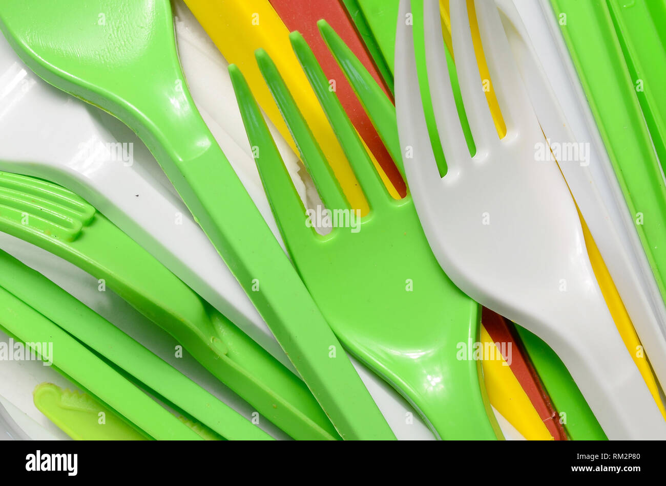 Pile of bright yellow, green and white used plastic kitchenware ...