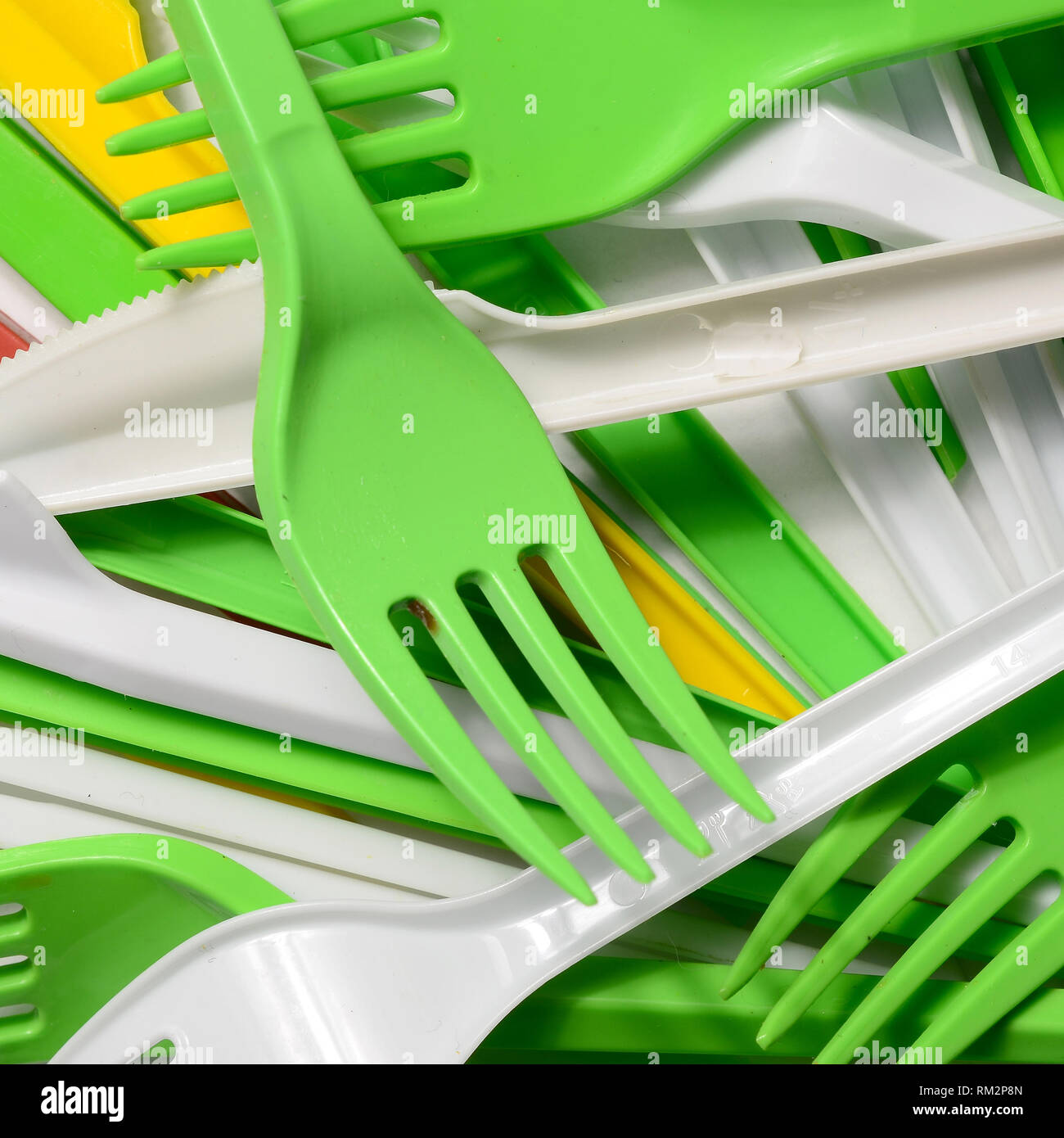 Pile of bright yellow, green and white used plastic kitchenware ...