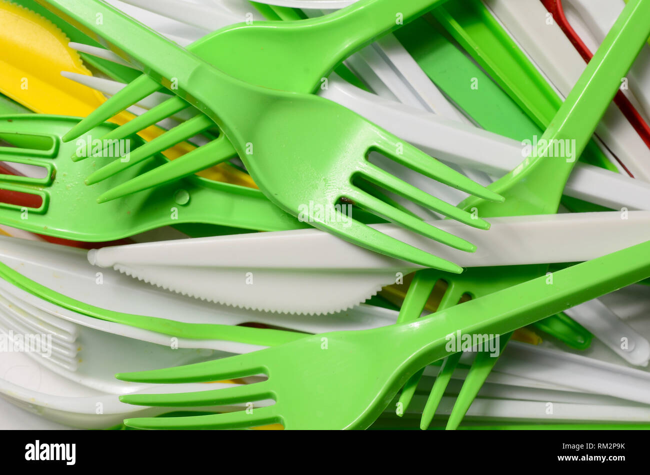Pile of bright yellow, green and white used plastic kitchenware ...