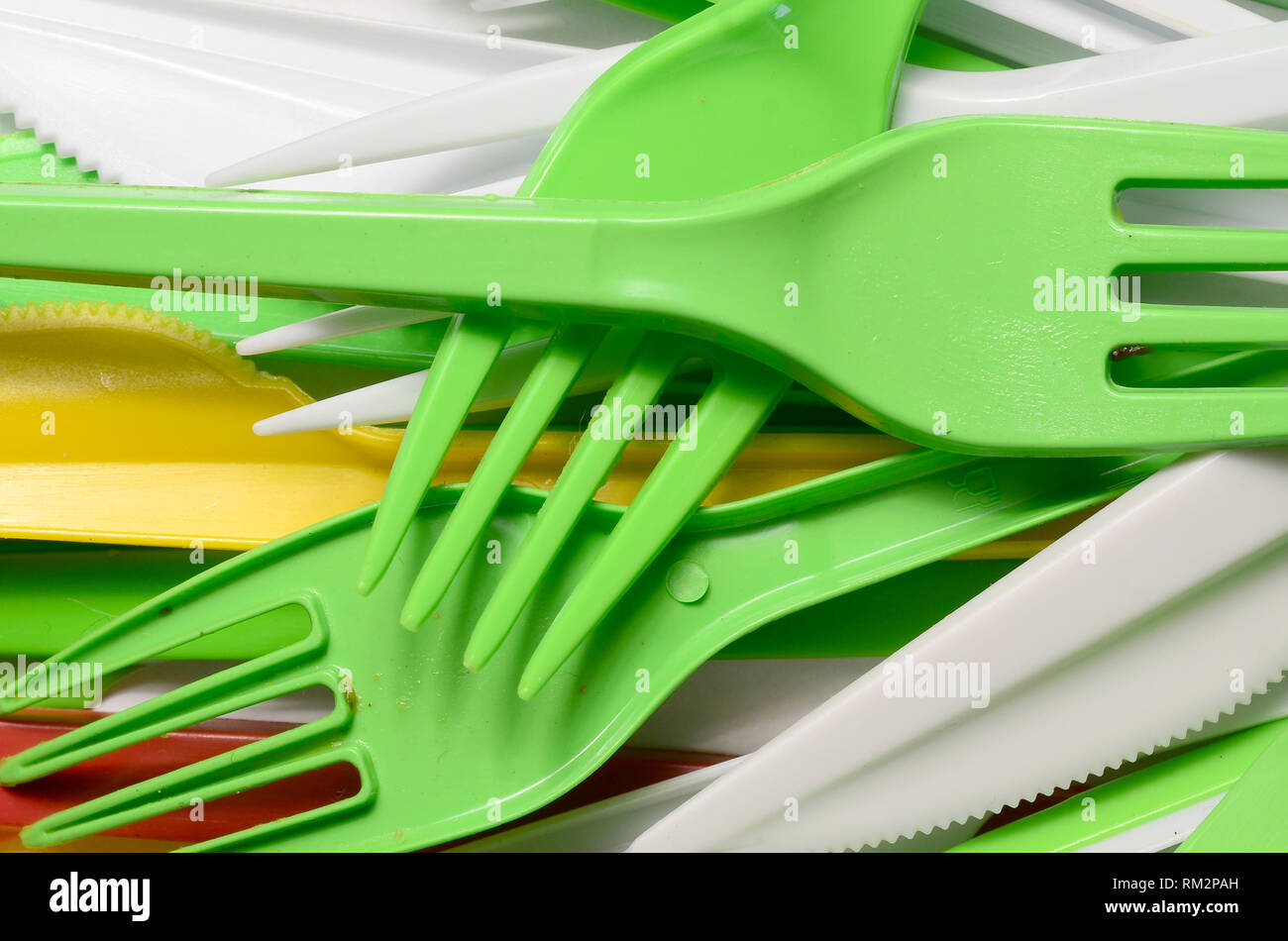Pile of bright yellow, green and white used plastic kitchenware ...