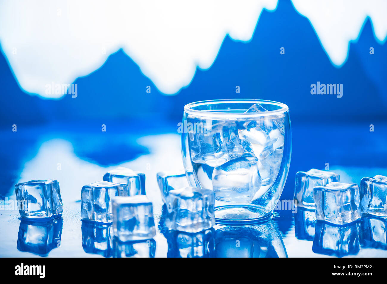 Double wall glass of clear water on a cold background with ice cubes ...