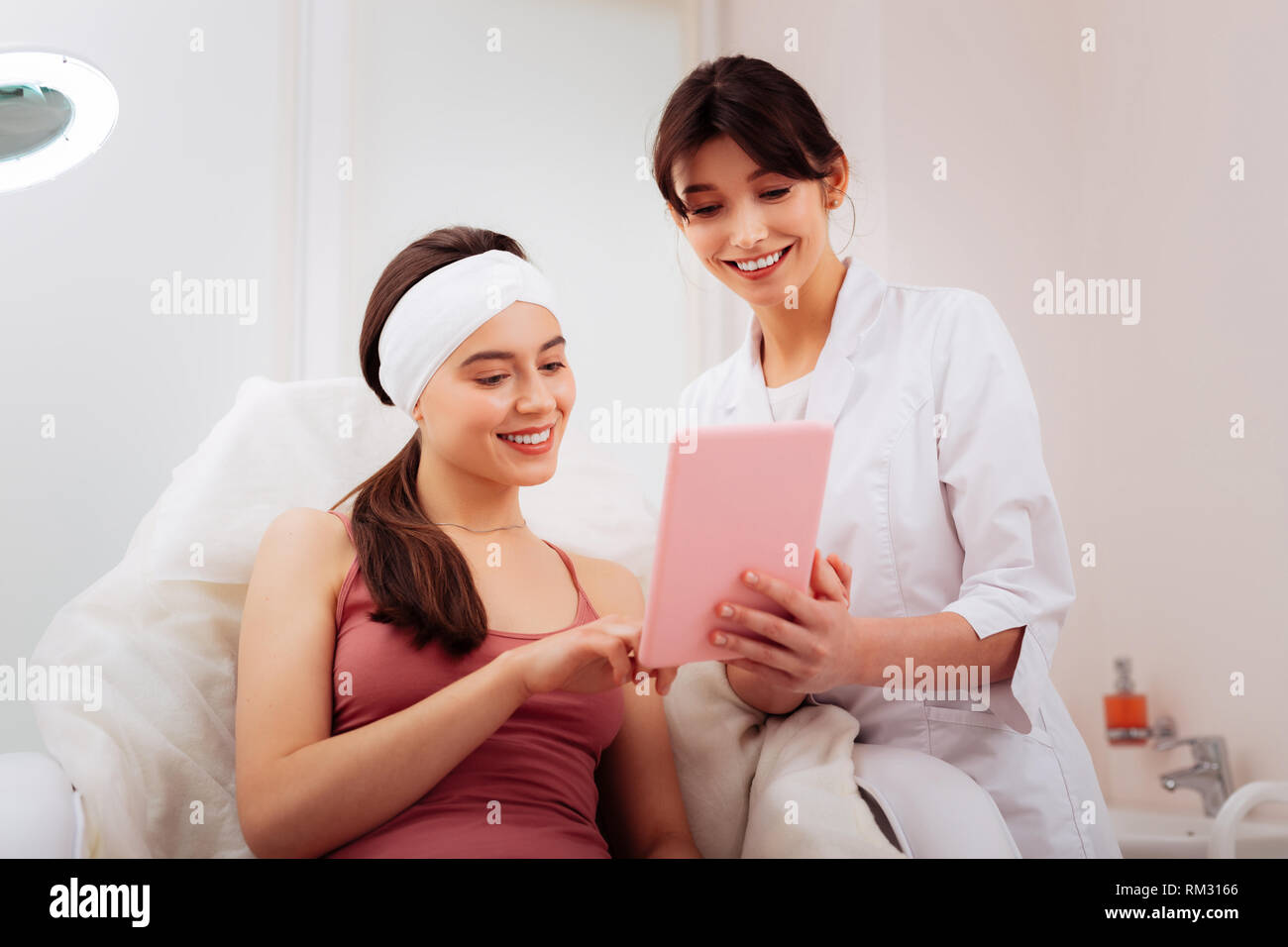 Joyful nice woman pressing the tablet screen Stock Photo - Alamy
