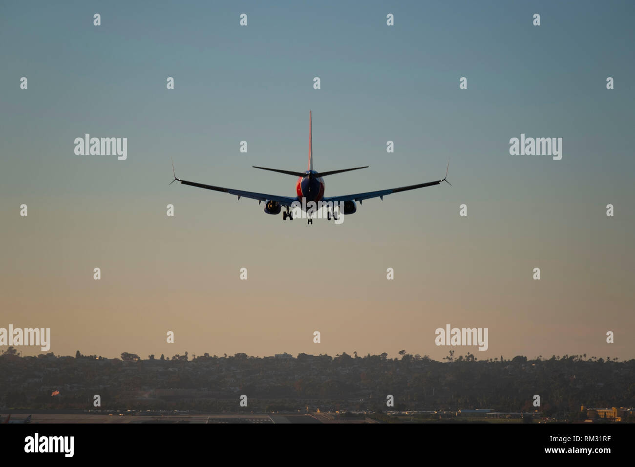 Passenger Jet flying at sunset Stock Photo - Alamy