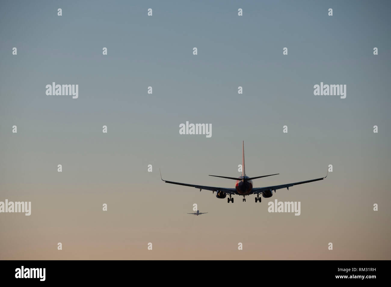 Passenger Jet flying at sunset Stock Photo - Alamy