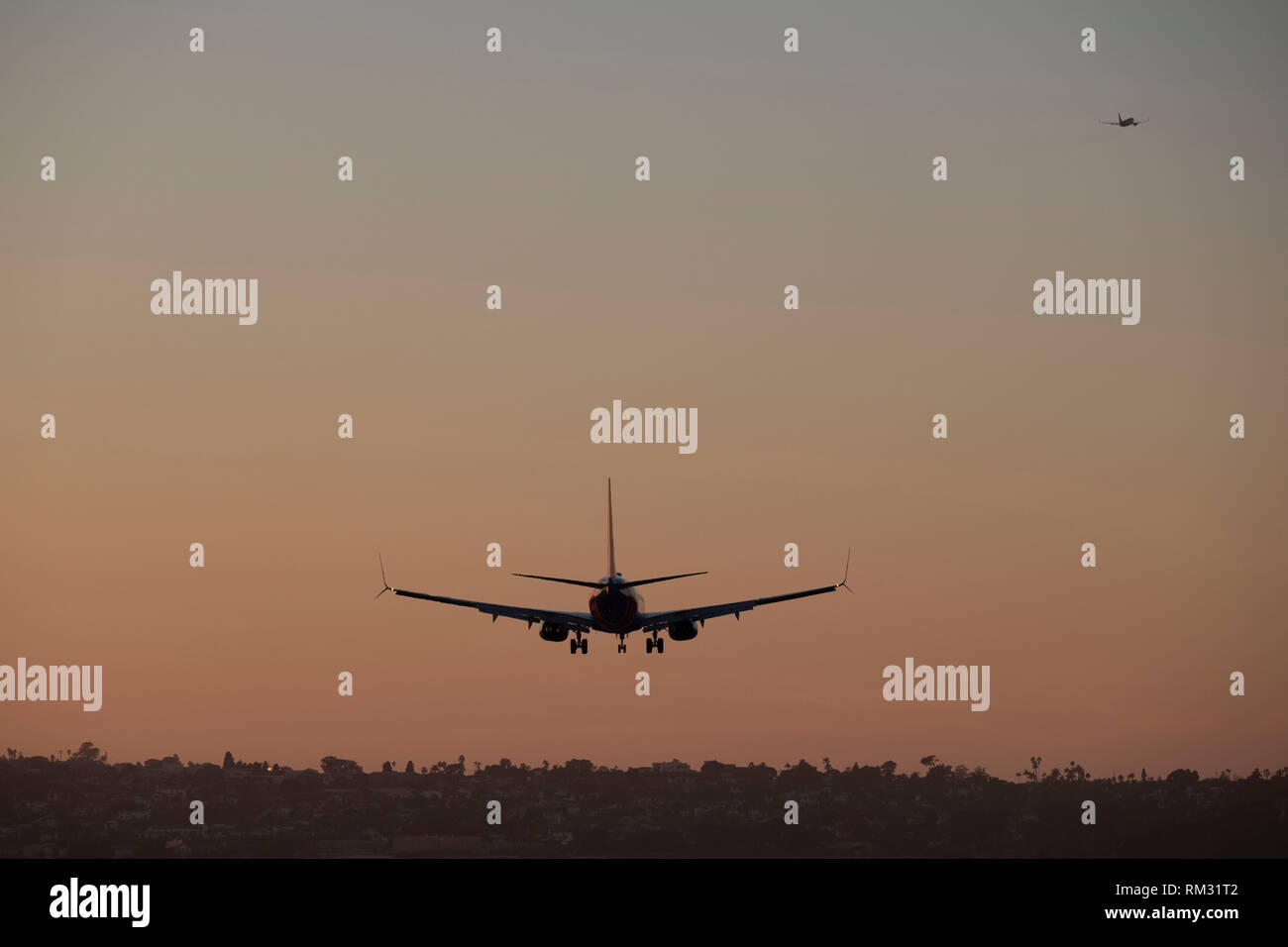Passenger Jet flying at sunset Stock Photo - Alamy