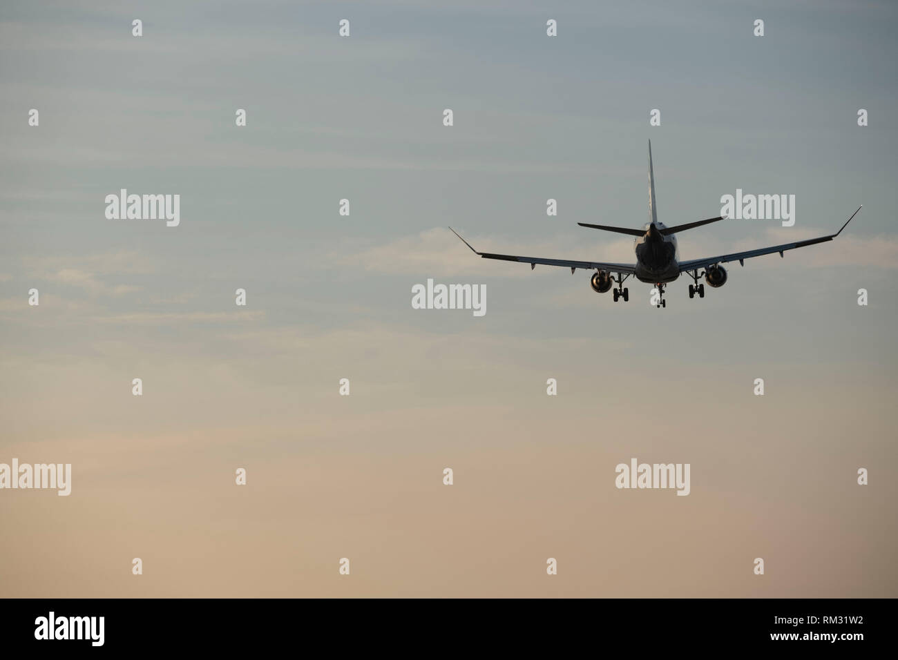 Passenger Jet flying at sunset Stock Photo - Alamy