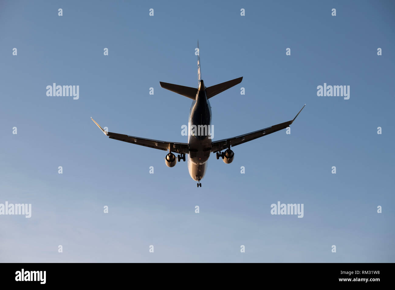 Passenger Jet flying at sunset Stock Photo - Alamy