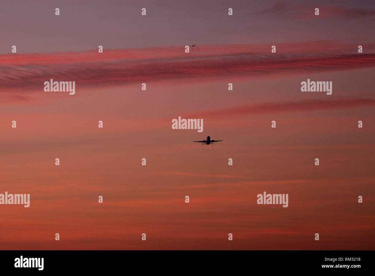 Passenger jet flying into the sunset Stock Photo - Alamy
