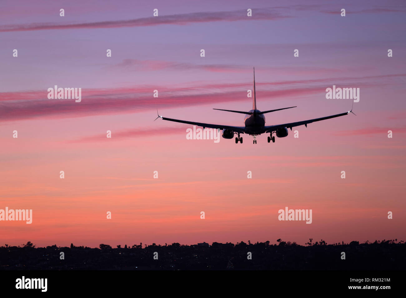 Passenger jet flying into the sunset Stock Photo - Alamy