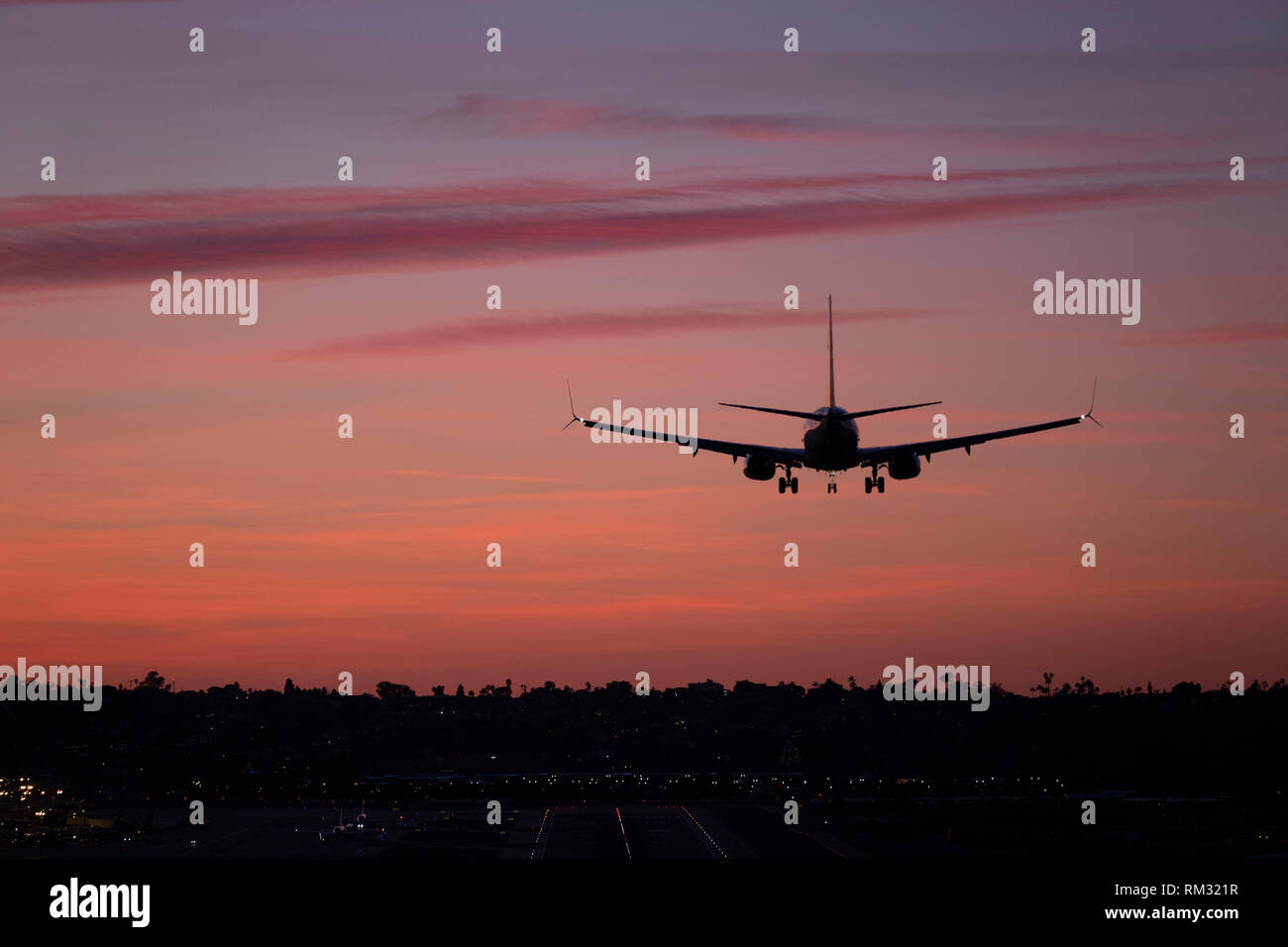 Passenger jet flying into the sunset Stock Photo - Alamy