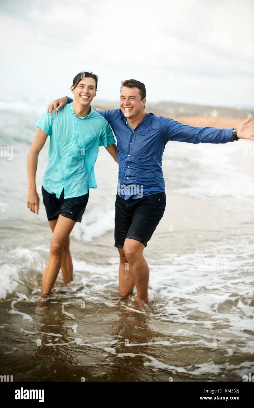 Two young men at Potamos beach, in holiday destination Malia, Crete ...
