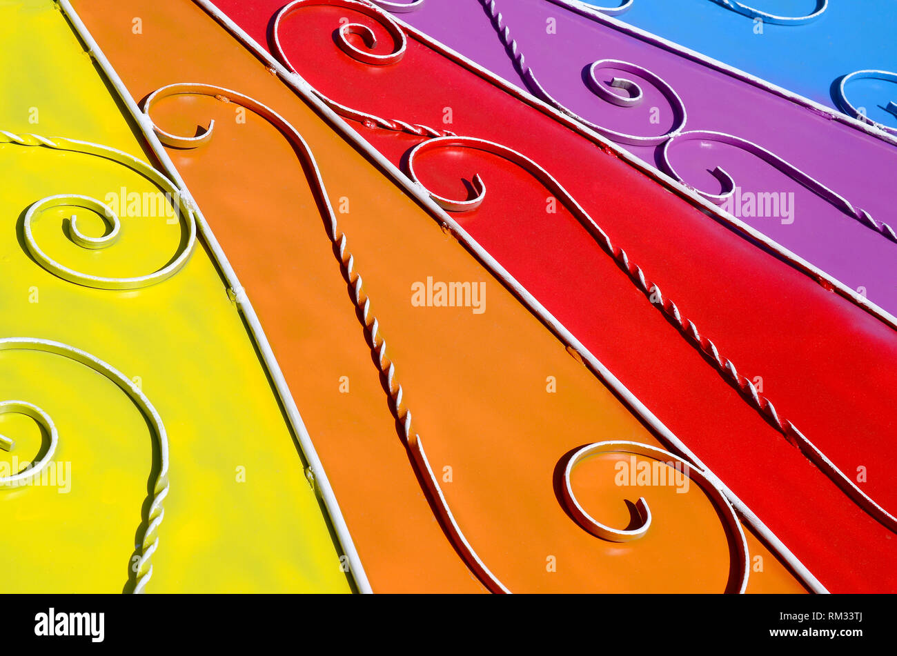 Metal texture of a piece of colored wall with a forged pattern. Rainbow ...