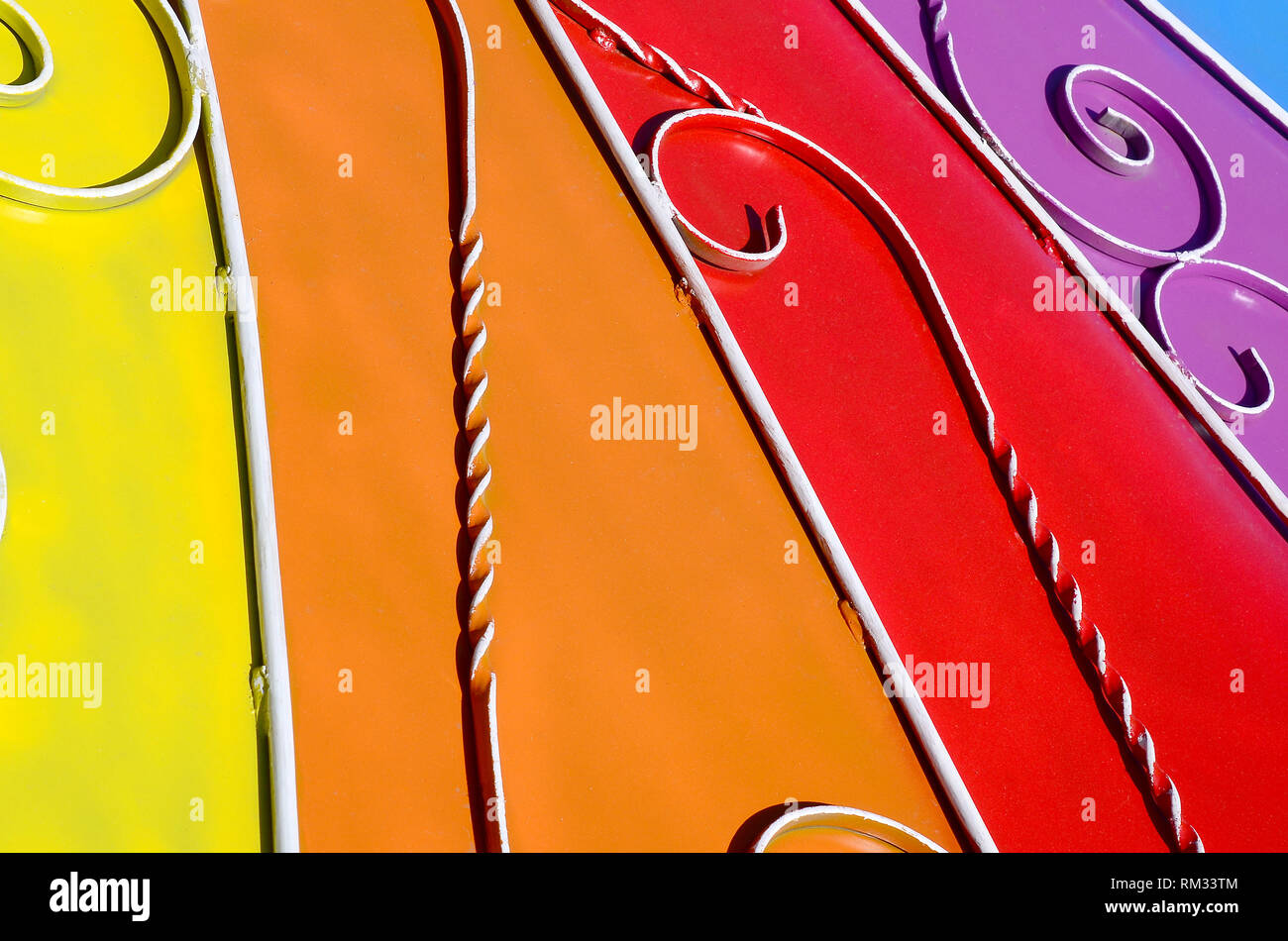 Metal texture of a piece of colored wall with a forged pattern. Rainbow ...