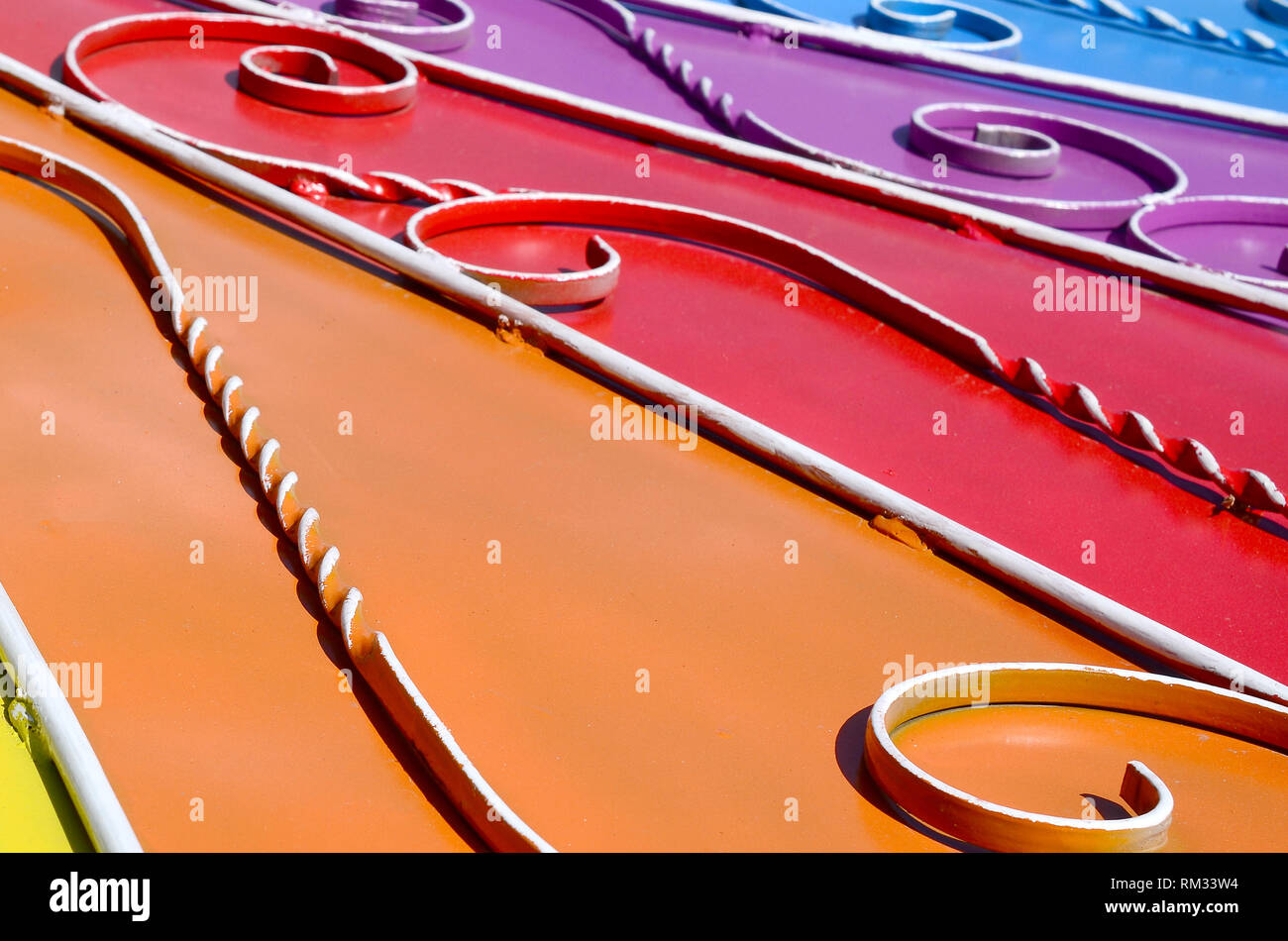 Metal texture of a piece of colored wall with a forged pattern. Rainbow ...