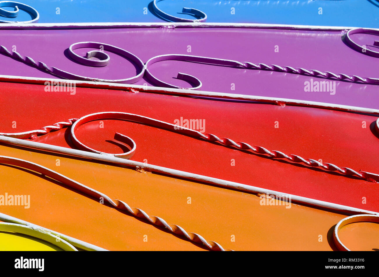 Metal texture of a piece of colored wall with a forged pattern. Rainbow ...
