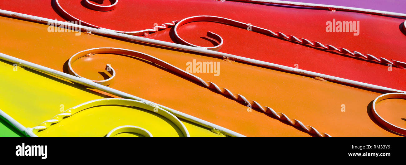 Metal texture of a piece of colored wall with a forged pattern. Rainbow ...