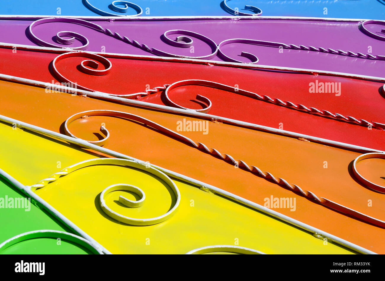 Metal texture of a piece of colored wall with a forged pattern. Rainbow ...