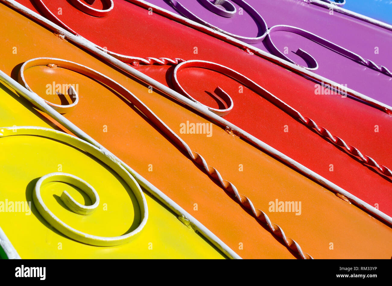 Metal texture of a piece of colored wall with a forged pattern. Rainbow ...
