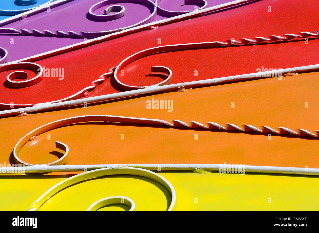 Metal texture of a piece of colored wall with a forged pattern. Rainbow ...