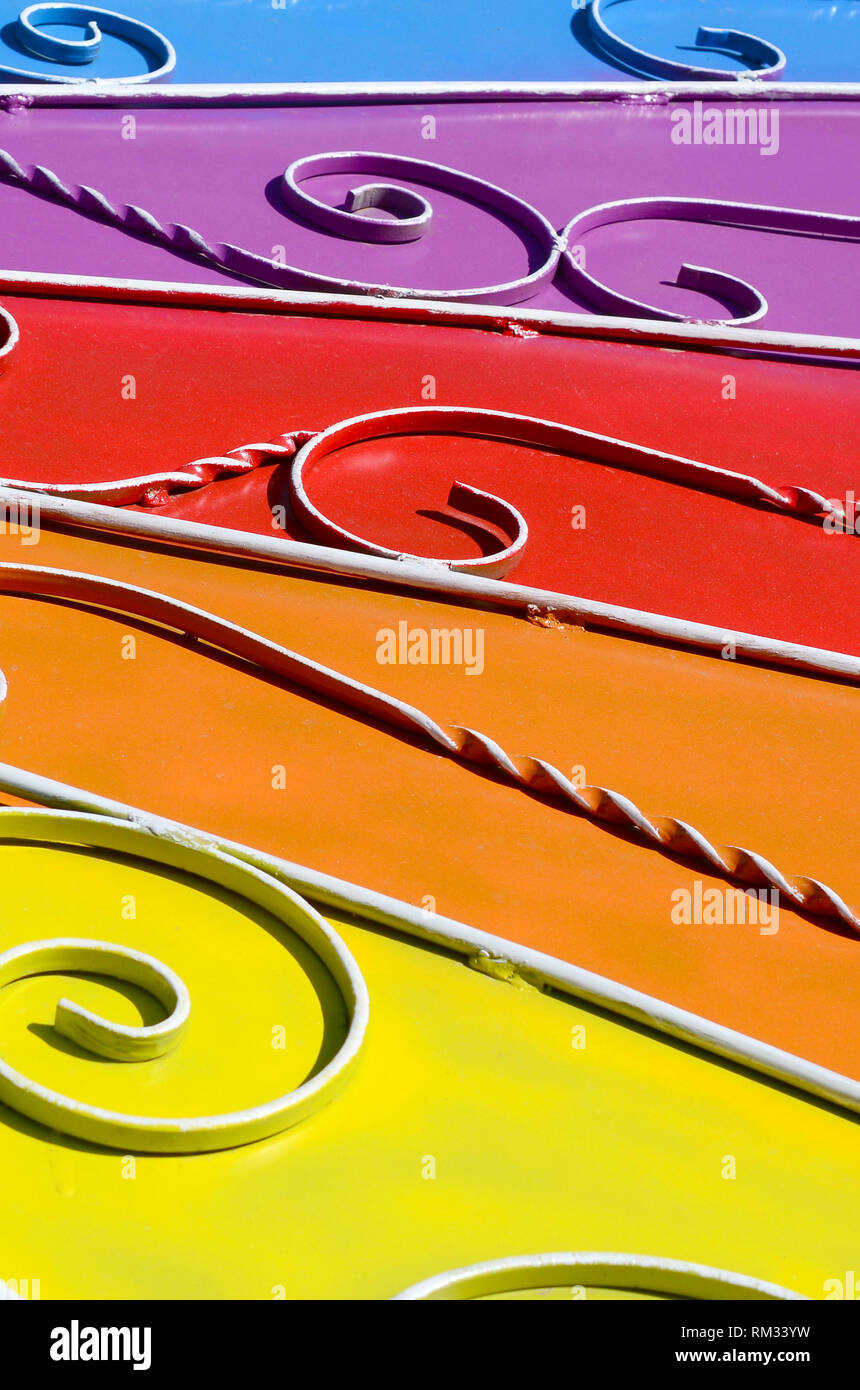 Metal texture of a piece of colored wall with a forged pattern. Rainbow ...