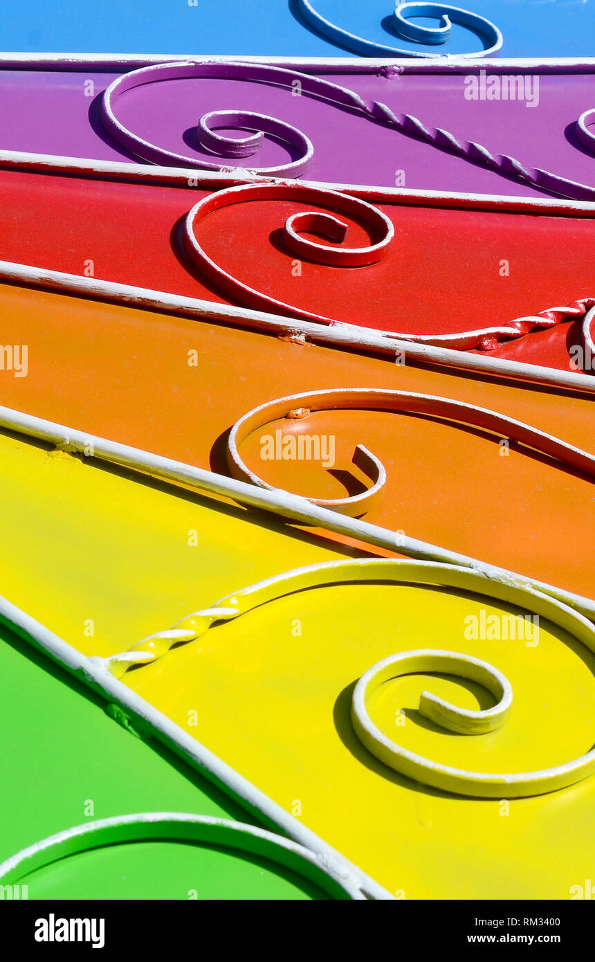 Metal texture of a piece of colored wall with a forged pattern. Rainbow ...