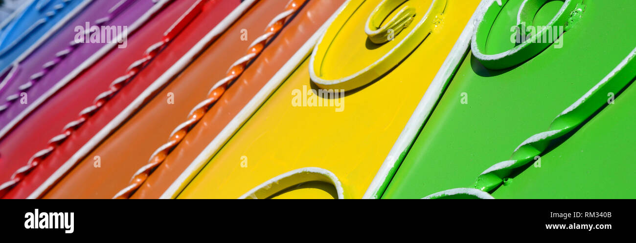 Metal texture of a piece of colored wall with a forged pattern. Rainbow ...