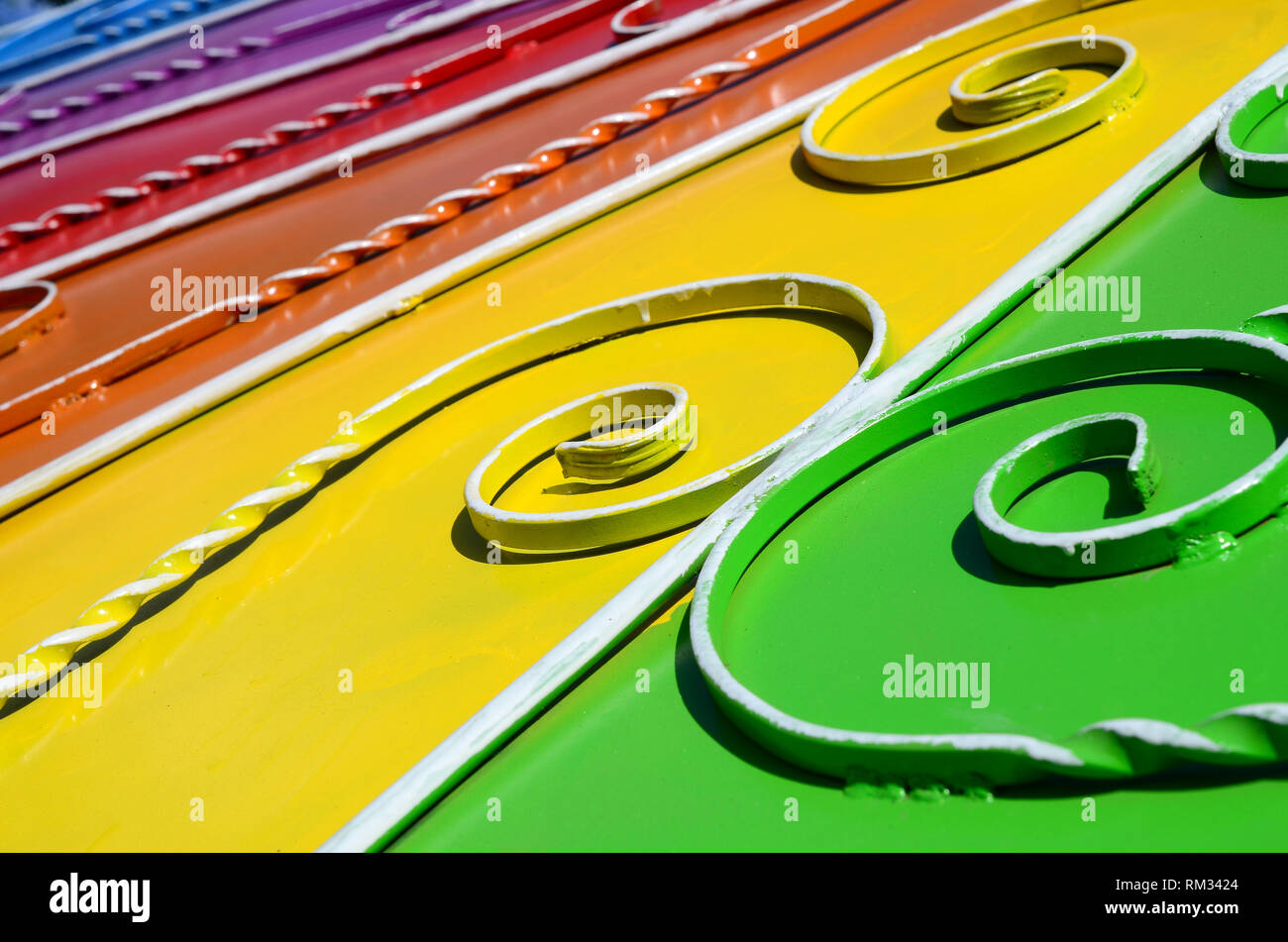 Metal texture of a piece of colored wall with a forged pattern. Rainbow ...
