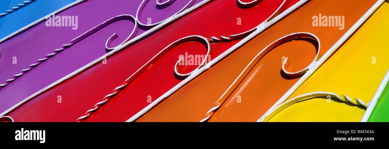 Metal texture of a piece of colored wall with a forged pattern. Rainbow ...