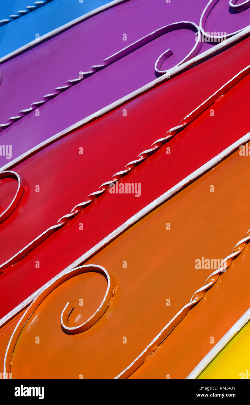 Metal texture of a piece of colored wall with a forged pattern. Rainbow ...
