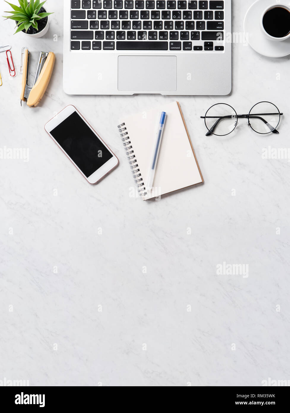 Stylized marble office working desk with smartphone, laptop, glasses ...