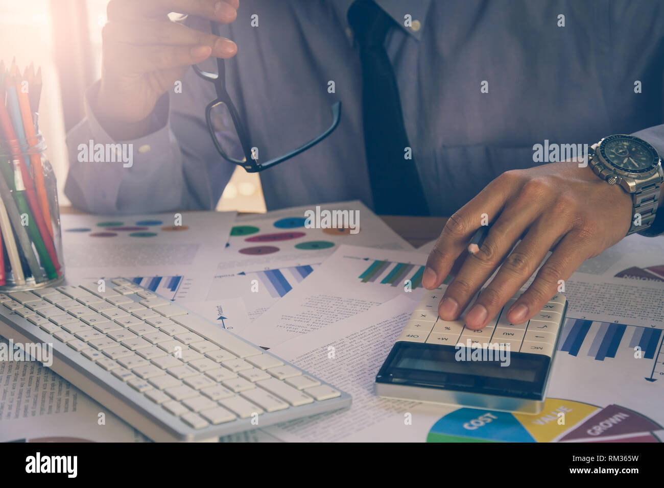 Businessman or accountant working on calculator to calculate business ...